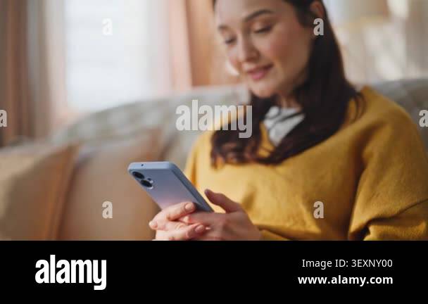 Girl surfing cellphone internet relaxing sofa at cozy domestic weekend ...
