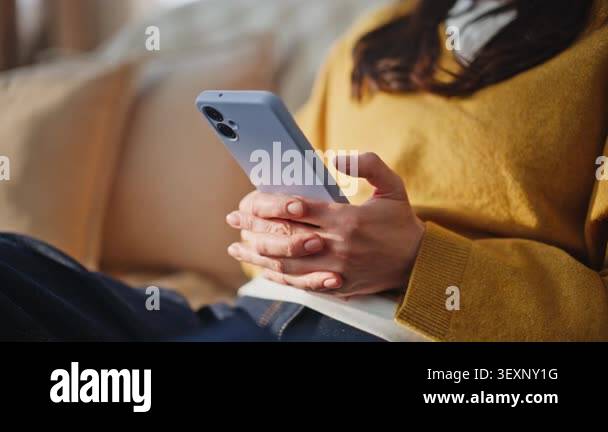 Girl hands texting messages cellphone relaxing home living room closeup ...