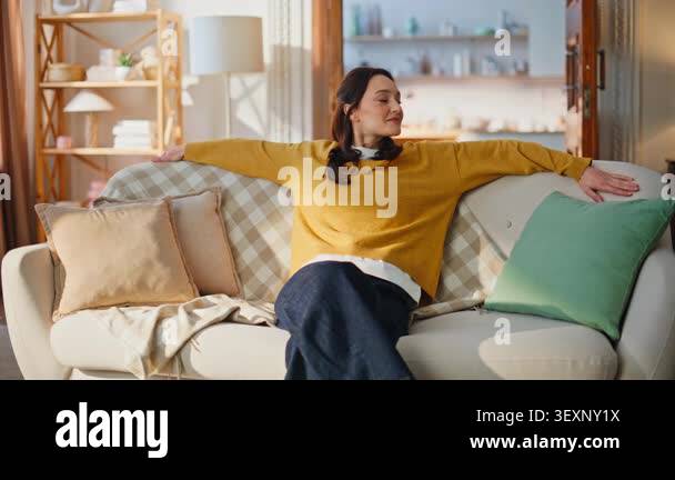 Woman leaning sofa back relaxing apartment after daily activities ...