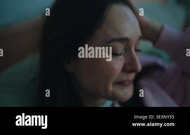 Heartbroken lady crying uncontrollably sitting bed at sleepless evening ...