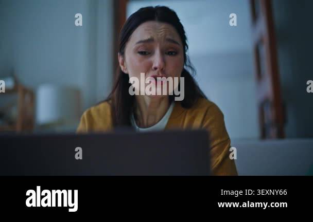Mad brunette quarrelling laptop web camera sitting home couch closeup ...