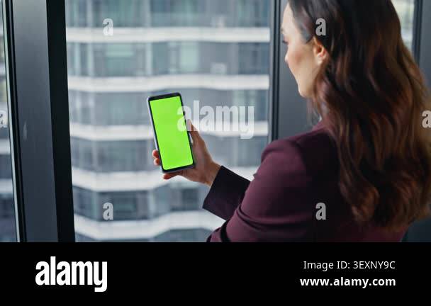 Closeup businesswoman holding mockup cellphone in panoramic window ...