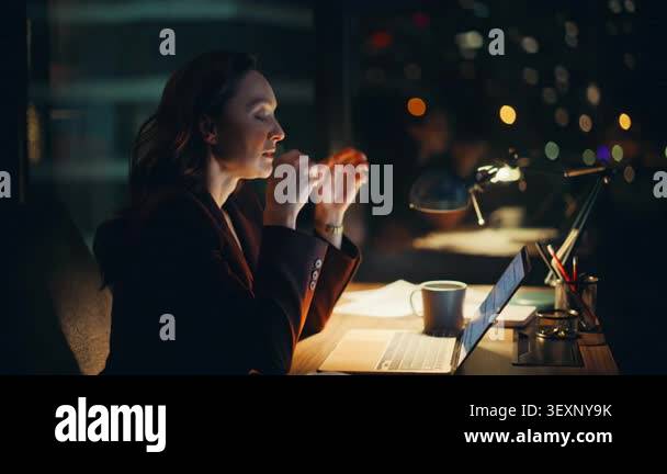 Tired brunette ending smartphone call sitting dark remote workplace ...