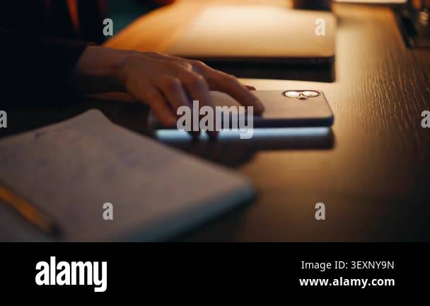 Closeup hand putting smartphone on table in night home. Unrecognizable ...