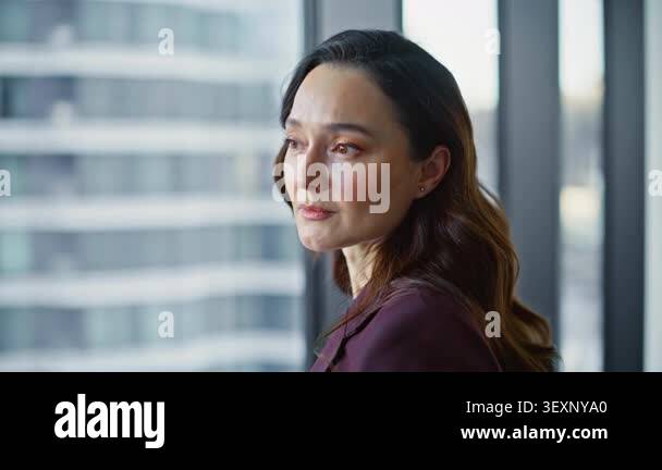 Worried woman executive standing window office high rise building ...