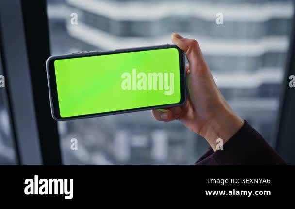 Lady hand holding mockup smartphone at panoramic creative agency ...