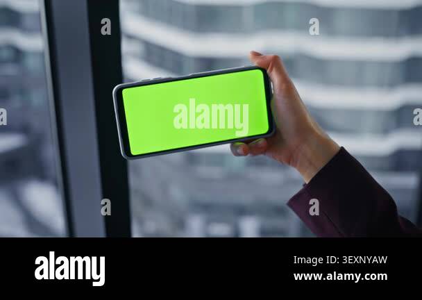 Fingers holding mockup mobile phone in modern office closeup. Relaxed ...