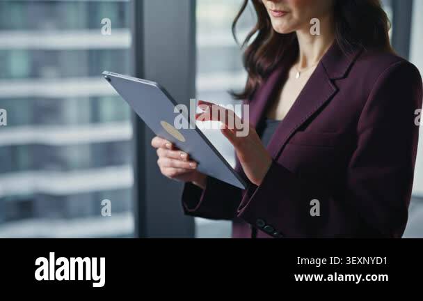 Woman fingers tapping tablet online standing by private cabinet window ...