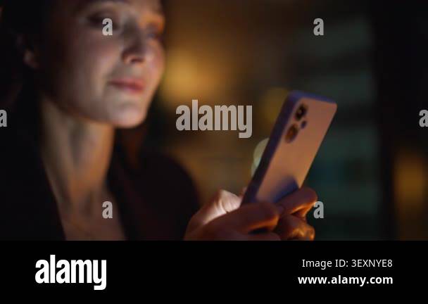 Night manager messaging cellphone at workplace lit with lamp light ...
