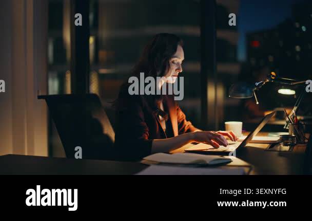 Overworked woman typing laptop staying late at evening workspace ...
