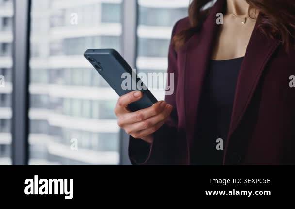 Strolling businesswoman holding smartphone reading sms walking modern ...