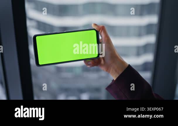 Hand holding horizontal mockup mobile phone at modern office closeup ...
