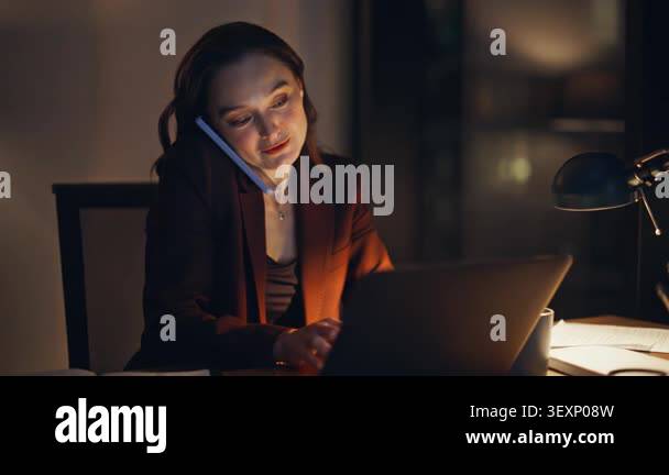 Overtime manager calling mobile phone discussing business ideas in dark ...
