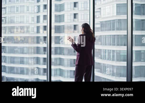Office professional calling smartphone looking panoramic window at grey ...