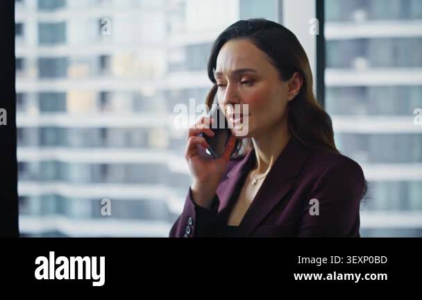 Wealthy business lady calling mobile phone standing office panoramic ...