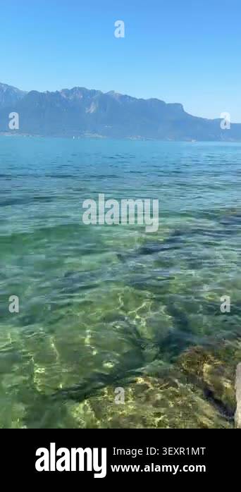Crystal clear turquoise water of Lake Geneva with Swiss Alps mountains ...