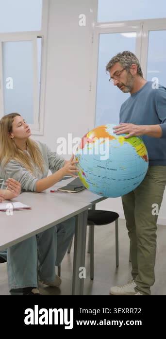 Geography professor teaching a lesson about the world to a group of ...