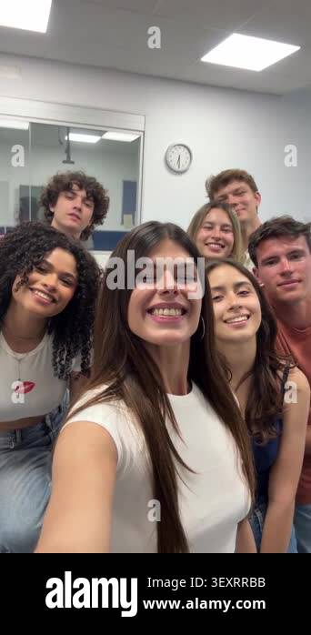 Happy young students smiling, waving, and gesturing at the camera. A ...