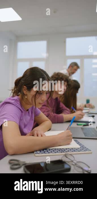 Young high school student diligently taking notes during a class ...