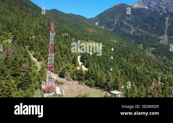 Aerial shot of a cellular antenna installed on elevated terrain within ...