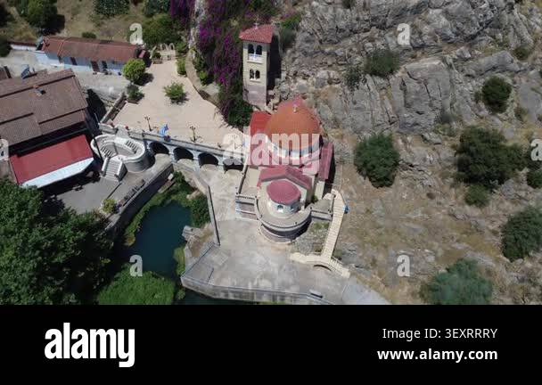 Wide aerial view shows a church, bridge, lake with lilies and ...