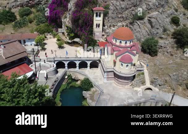 Wide aerial shot shows a church, traditional bridge, water source ...