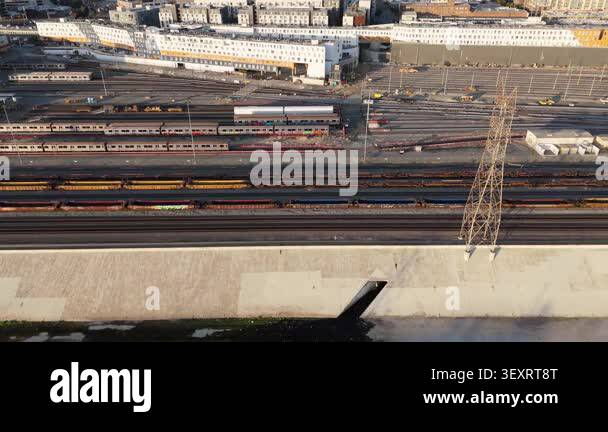 Drone flies over a dense network of train tracks and a concrete-lined ...