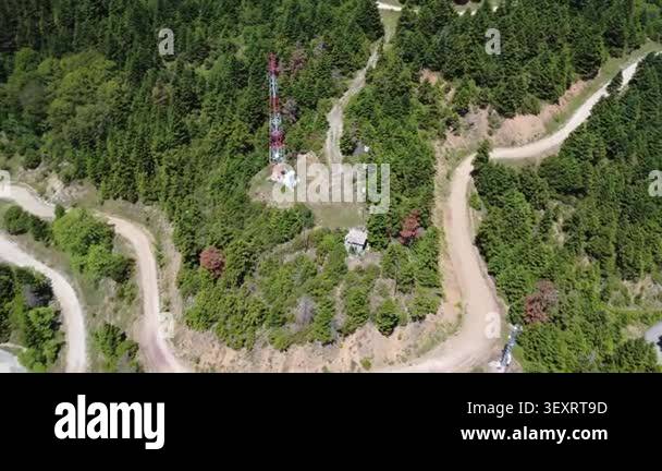 Aerial shot focused on a signal tower, substation and service vehicle ...