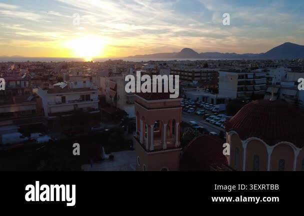 Aerial panoramic cityscape during sunset featuring a church bell tower ...