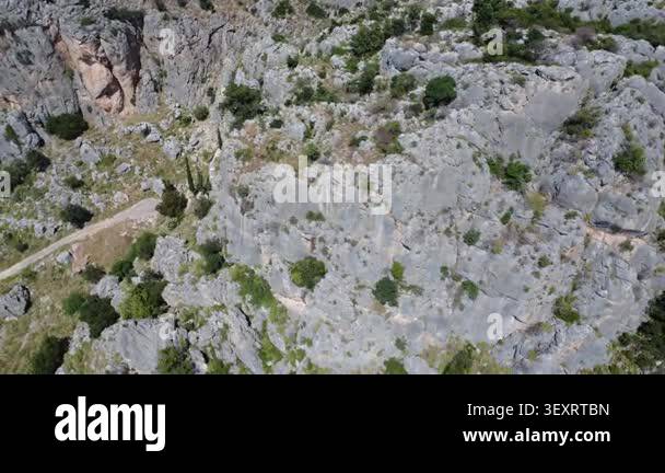 Aerial view of a traditional chapel tucked into a rugged mountain gorge ...