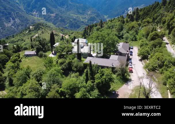Aerial panoramic view of a small stone village surrounded by dense fir ...