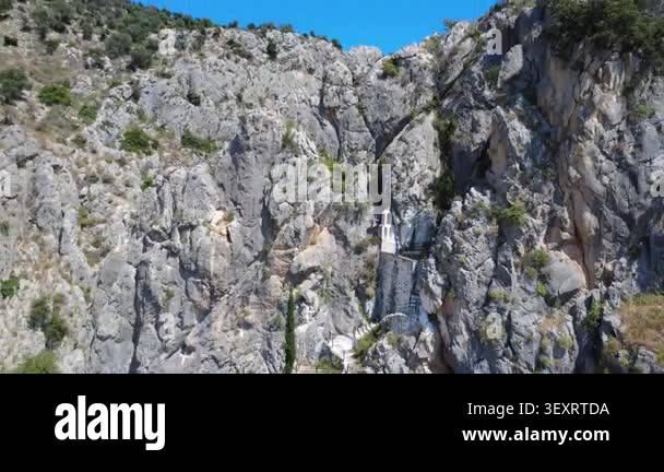 Aerial view reveals a rocky mountain canyon with a hidden traditional ...