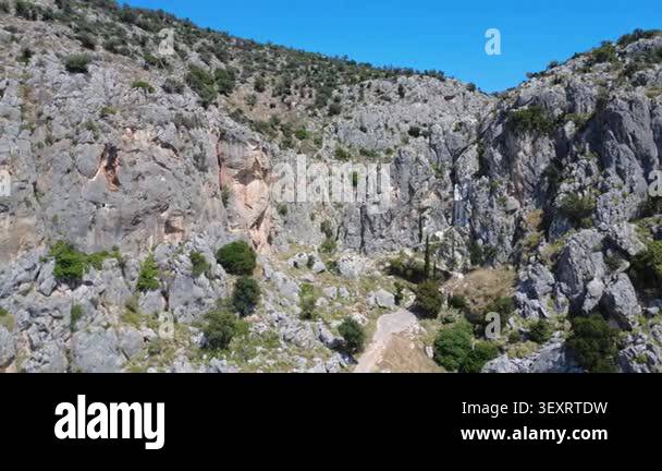 Aerial shot showing a chapel overlooking a canyon from a rugged slope ...