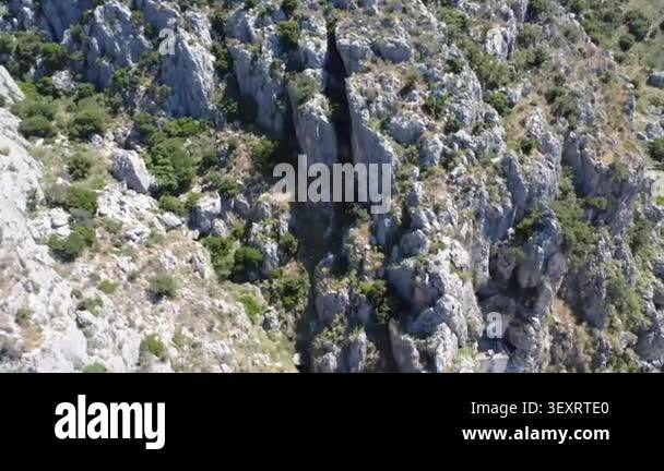 Aerial panorama of a rugged gorge featuring a secluded chapel within ...