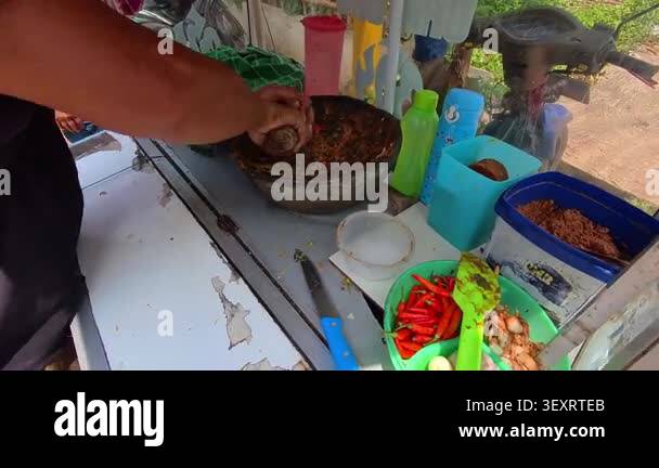 Video of Hand stirs peanut sauce in a large bowl. Vibrant peppers and ...