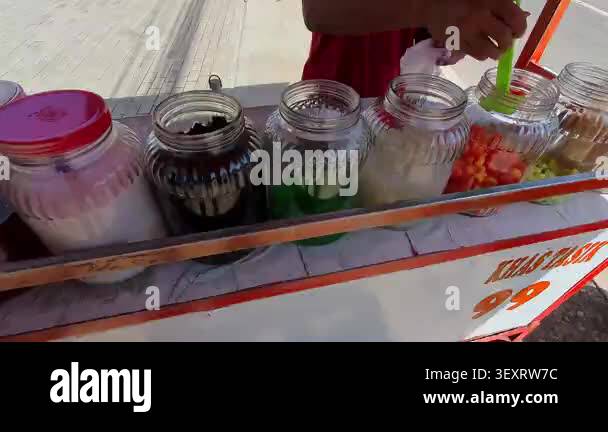 Video of Vendor preparing Fruits soup drinks from glass jars. Bright ...