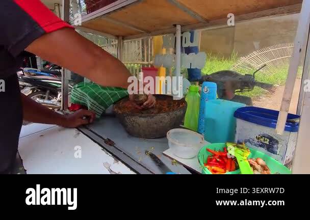 Video of Hand stirs peanut sauce in a large bowl. Vibrant peppers and ...