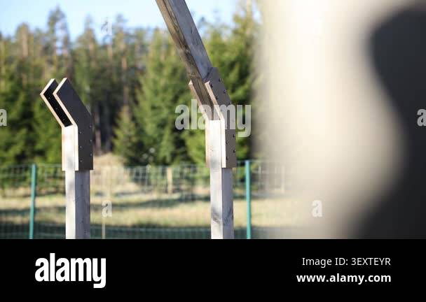 Close up of two timber posts with layered metal brackets and even ...