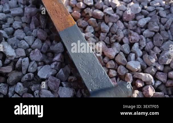 Close up shows hand using small roller to coat rusted steel flat bar on ...