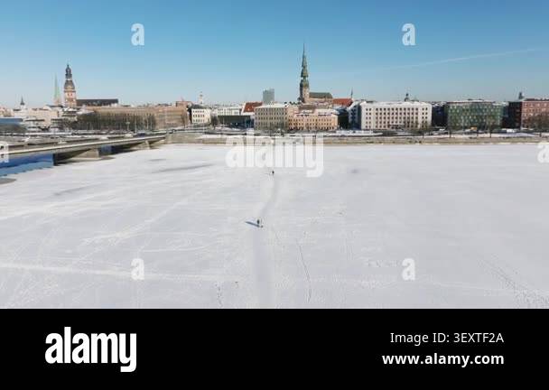 Aerial Riga in winter shows frozen Daugava, narrow walking track to Old ...