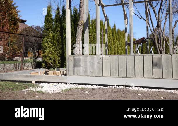 Timber greenhouse frame under construction with vertical wainscoting ...