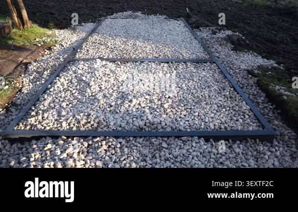 Rectangular steel frame sits in loose crushed stone as crossbars form a ...