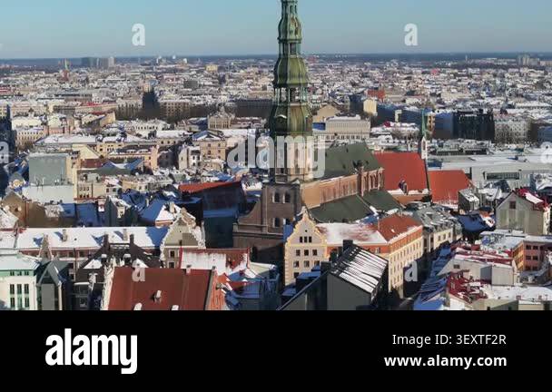 Aerial view shows St. Peter's Church spire over snow on Old Town Riga ...