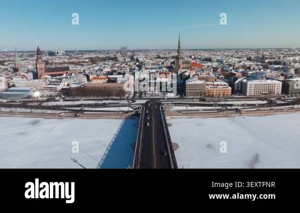 Aerial view of Riga in winter shows frozen Daugava River, bridge to Old ...