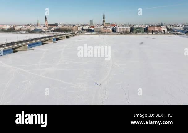 Aerial view of Riga in winter shows pedestrians on frozen Daugava ...