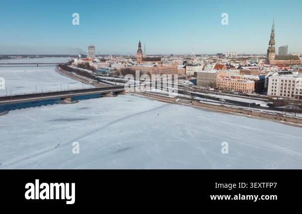 Aerial pans show frozen Daugava River, Old Town roofs, St. Peter's ...