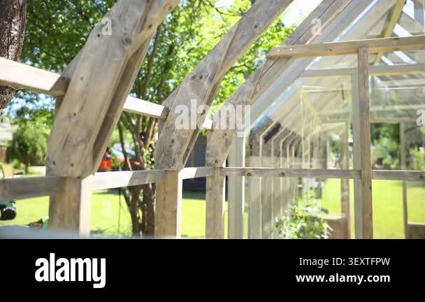 Wooden greenhouse interior shows curved timber ribs and tempered glass ...