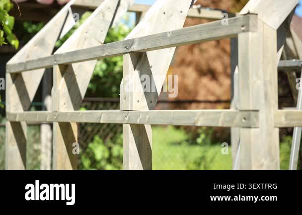 Pale timber frame with triangular braces and horizontal battens ...