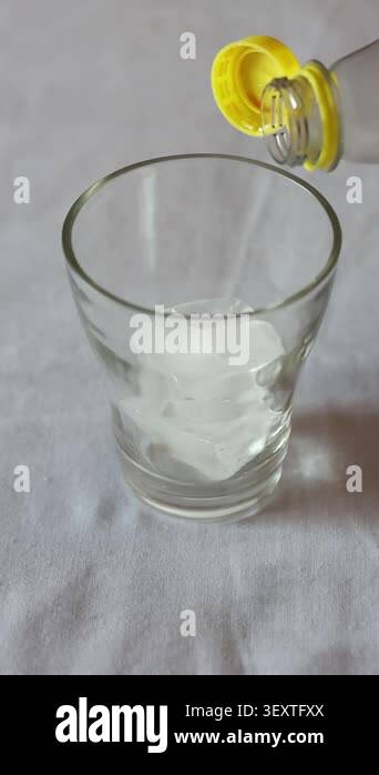 Refreshing red juice being poured from a bottle into a glass filled ...