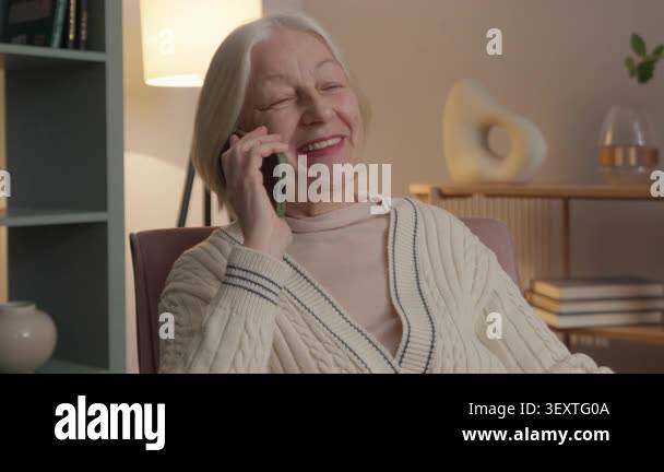 Happy Senior Woman Laughing During Phone Conversation In Cozy Home ...